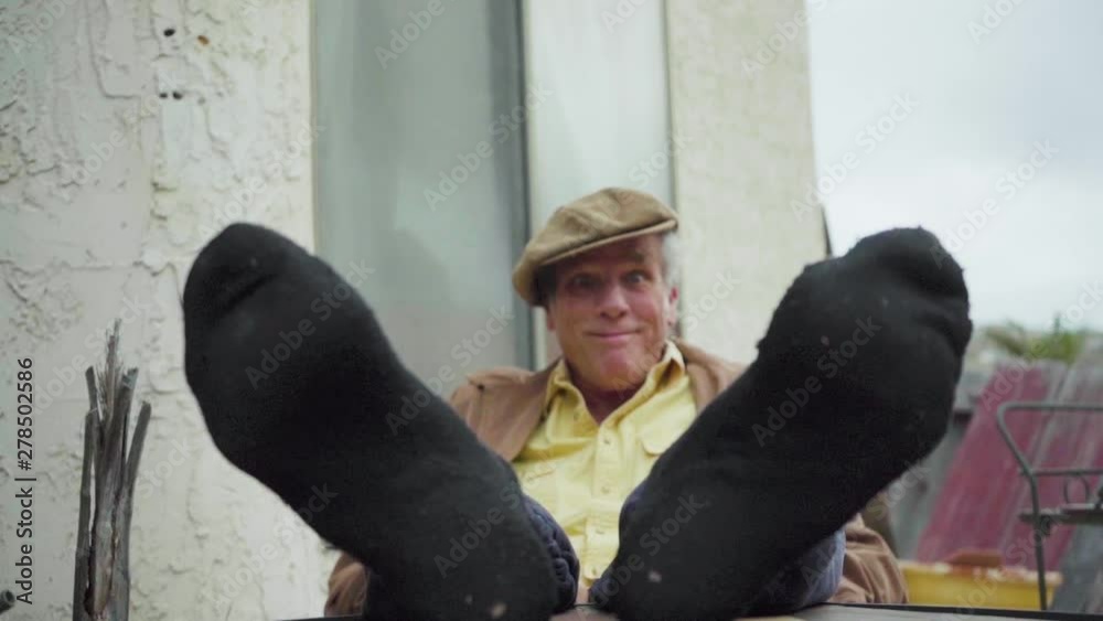 Funny old man with feet in socks on table then opening feet and ...