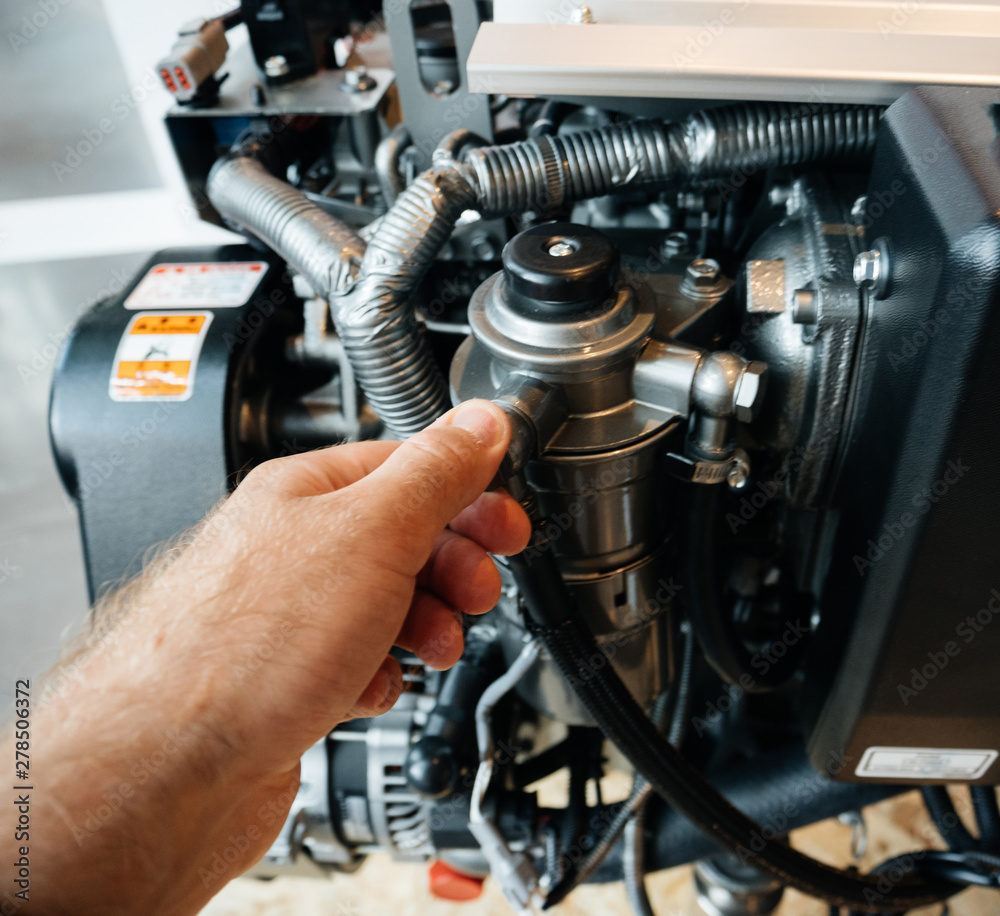 Male hand repairing demonstrating the new 4-stroke, vertical, water ...