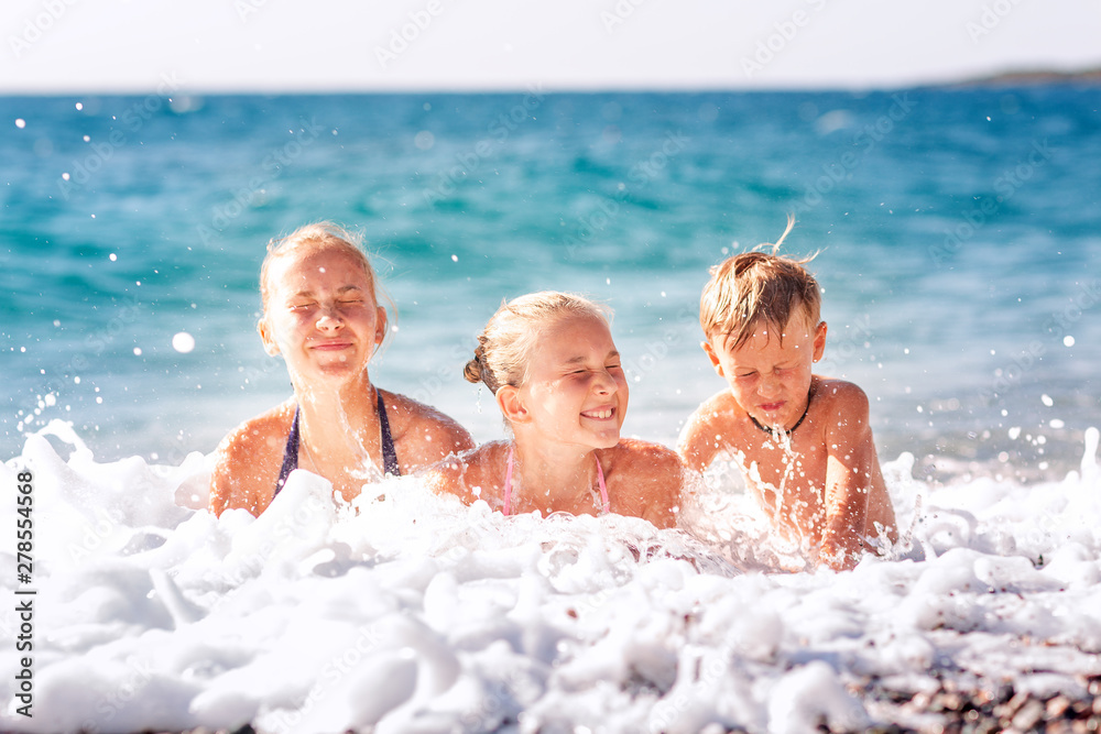 Happy kids on the beach having fun Stock Photo | Adobe Stock