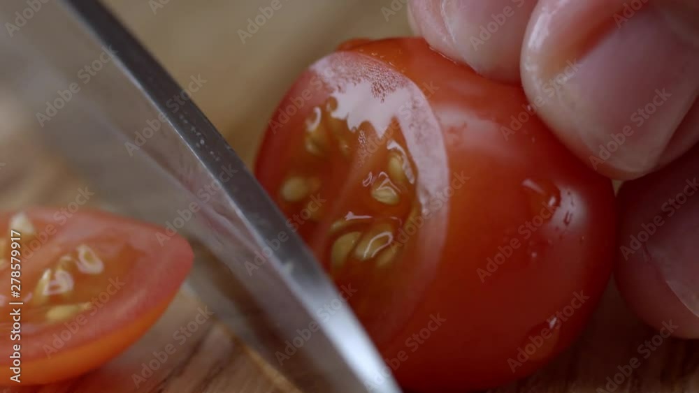 Vidéo Stock Tomato cutting closeup. Chef slices the cherry tomato ...