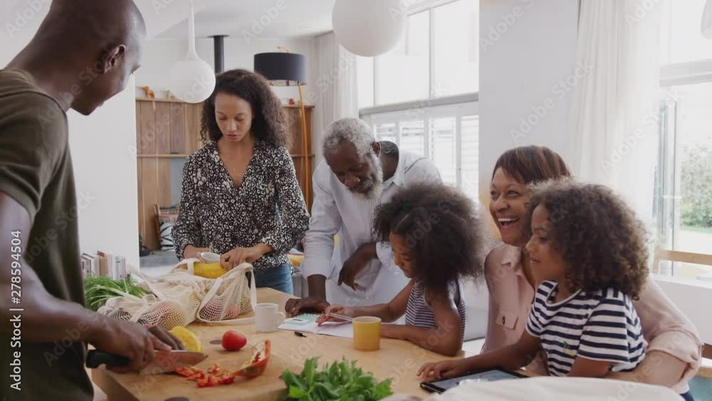 Grandparents Sitting At Table Helping Grandchildren With Homework As ...