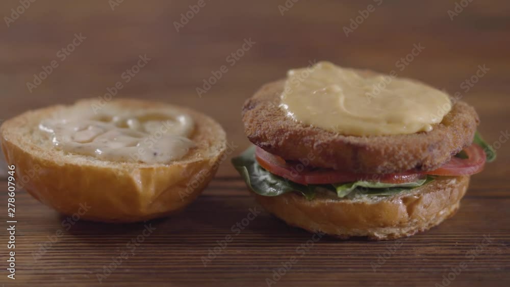 Hands of the chef making burger close-up. The cook putting melted ...