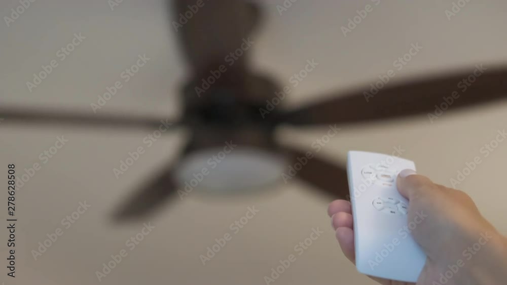 Fan on the control panel. A woman's hand turns on a fan on the ceiling ...