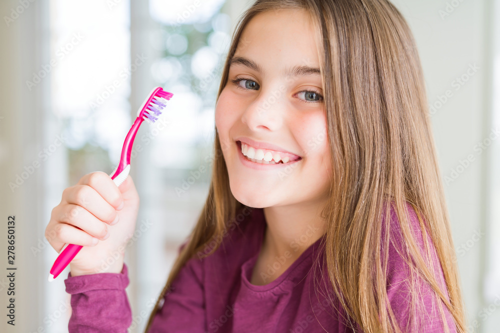 Beautiful young girl kid holding pink dental toothbrush with a happy ...