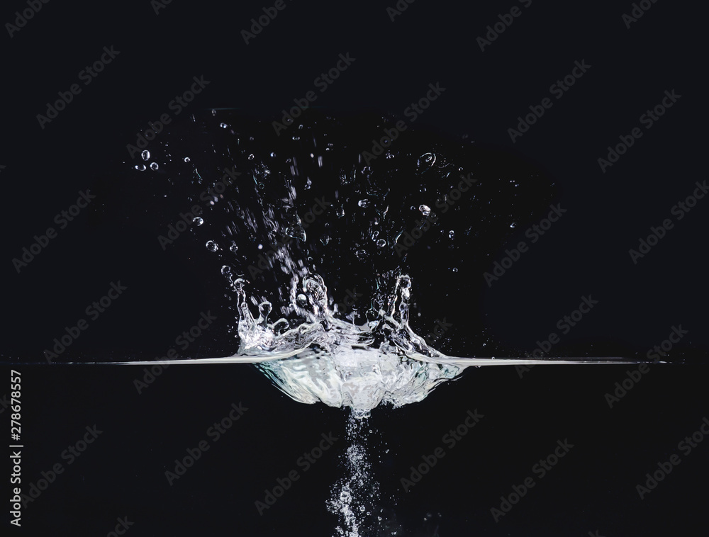 Water splash on liquid surface isolated on black background, close up ...
