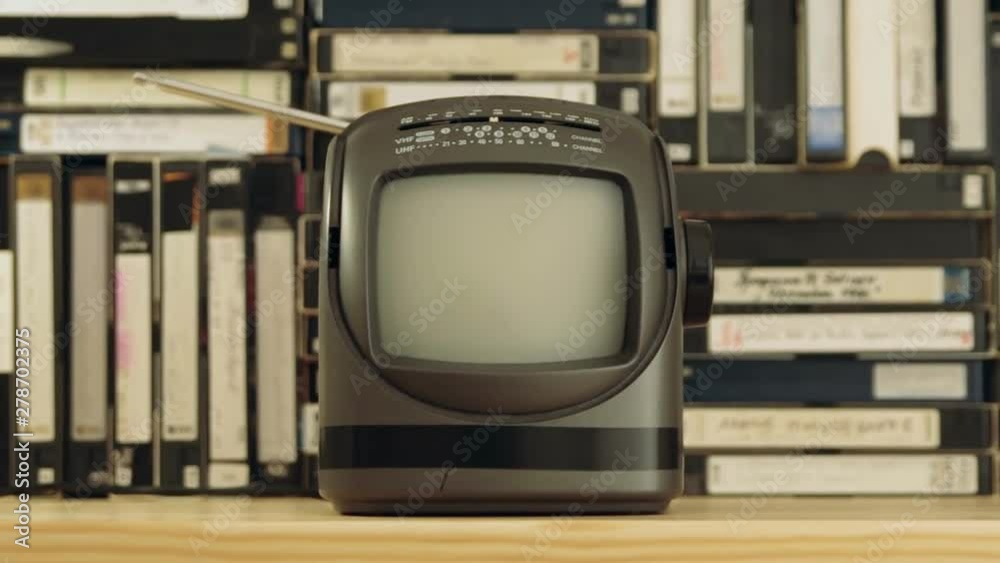 Old small TV set with antenna against background made of VHS and S-VHS ...