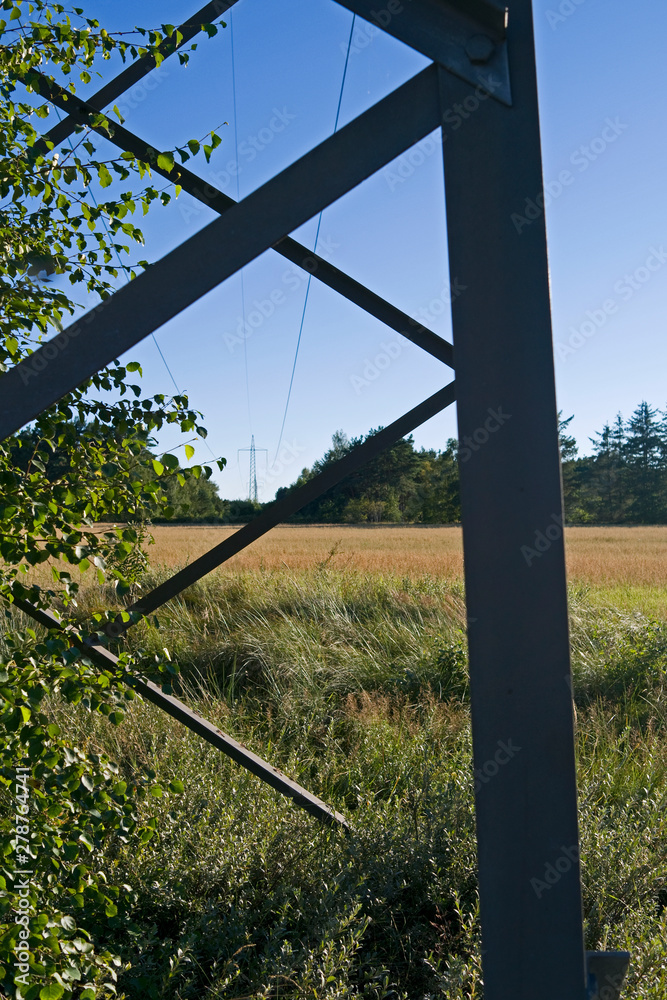Power Lines: View through a grid tower of the overhead high-voltage ...