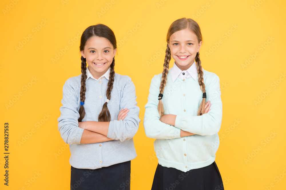 Studying together is fun. smart little girls on yellow background ...