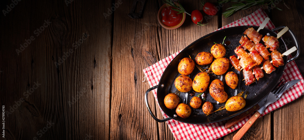 Rustic dates wrapped in bacon and young roasted potato. Stock Photo ...