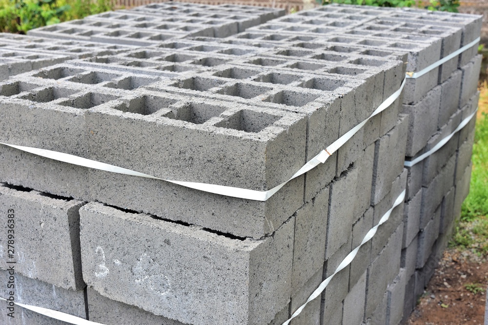 Stack of gray textured cinder blocks for house or fence building ...