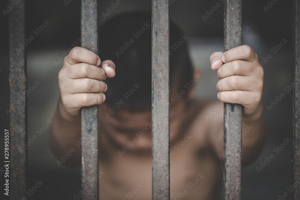 Hands of a young child clutching prison bars, victim child with locked ...