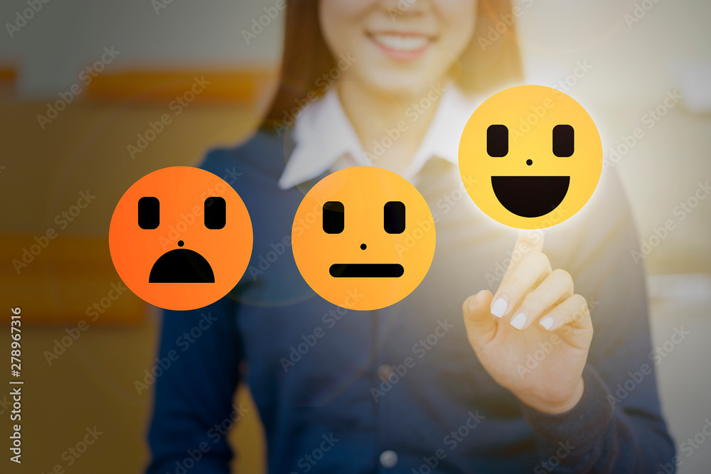 young Asian woman pointing or pressing smiley face emoticon or symbol ...