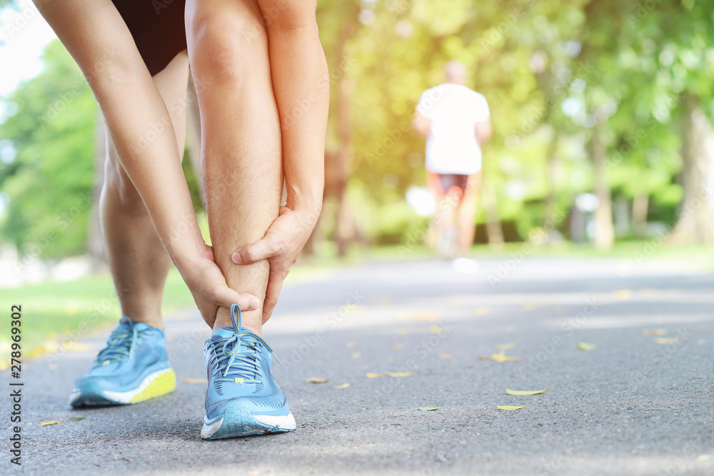 Runner touching painful twisted or broken ankle. Athlete runner ...