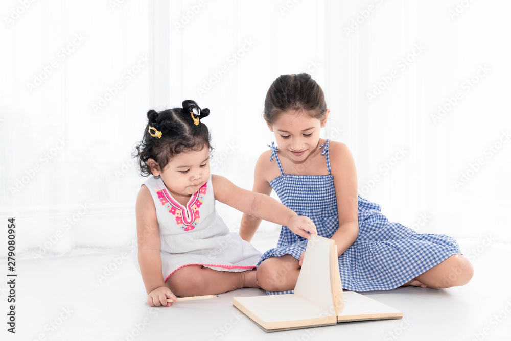 Happy two sister drawing in sketch book together at home or nursery ...