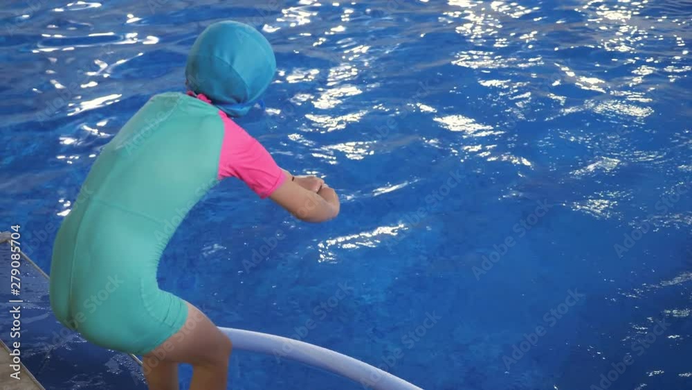 Little girl on swim lesson in sport school. Child girl learns to dive ...