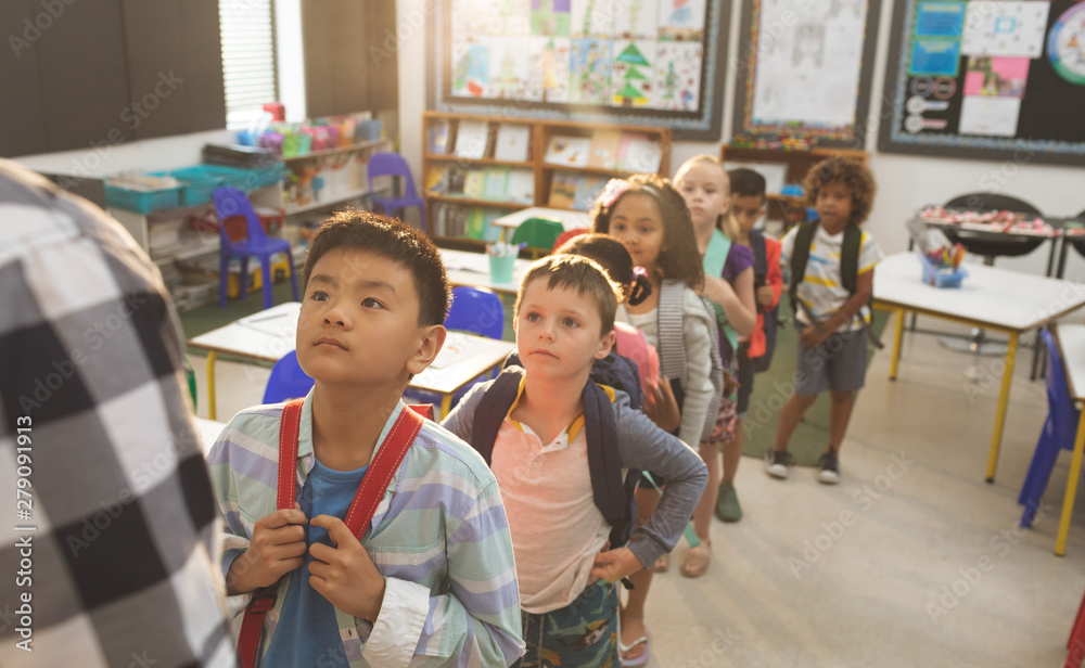 School kids standing and forming a queue in classroom at school Stock ...