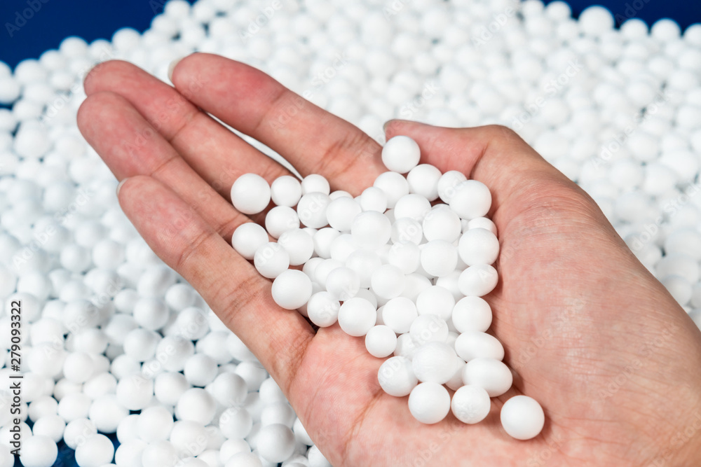 Hand holding white polystyrene foam beads ball drop from Styrofoam ...