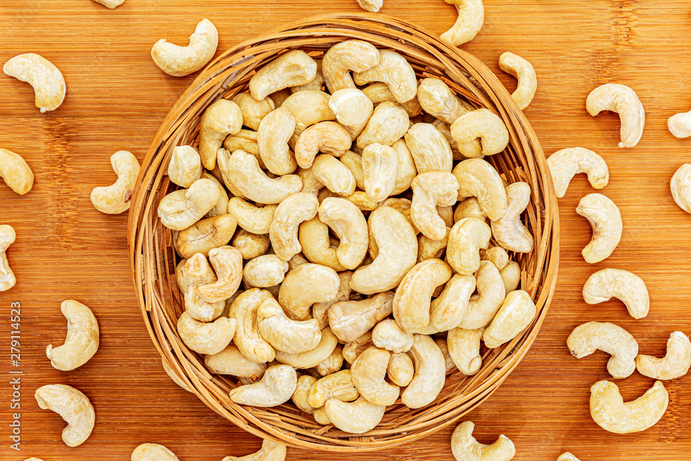 Healthy cashew nuts stuffed in wicker bowl on wooden background. Top ...
