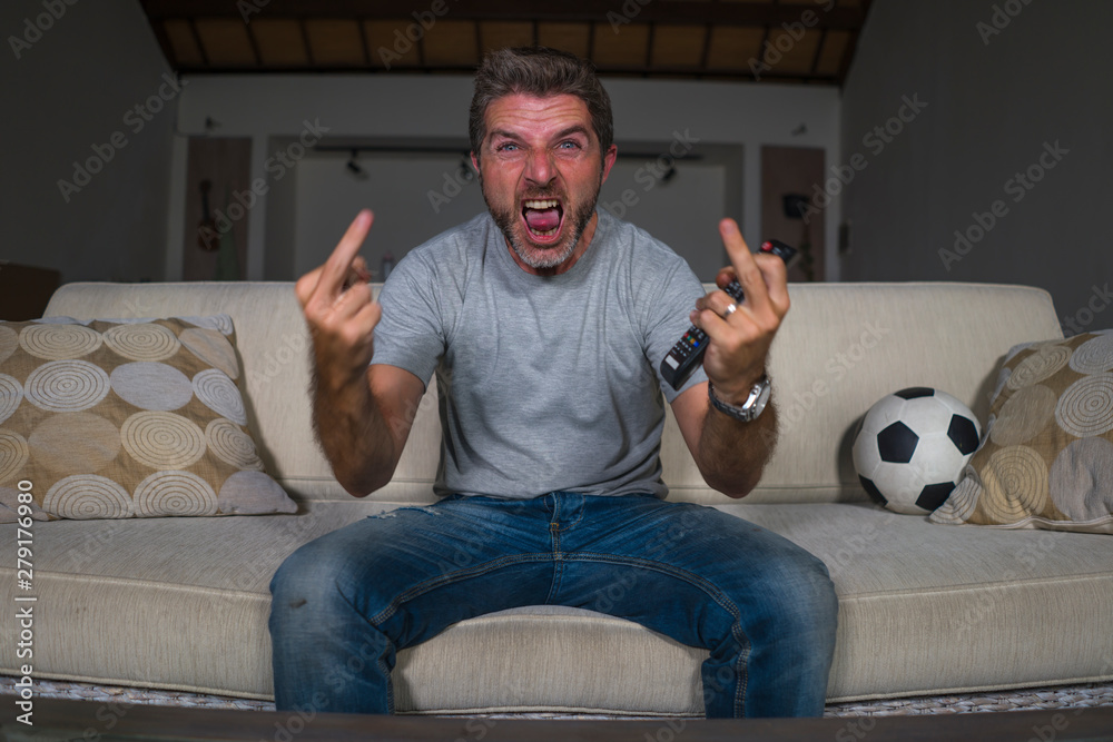 young crazy soccer fan man watching football game on television at ...