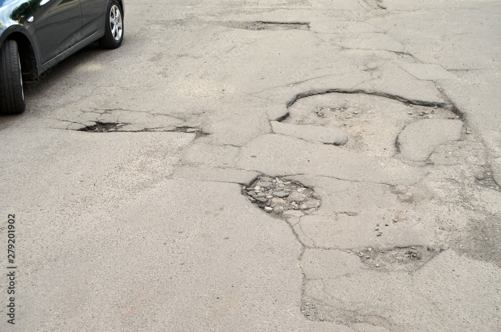 Poor condition of the road surface. Summer season. Hole in the asphalt ...