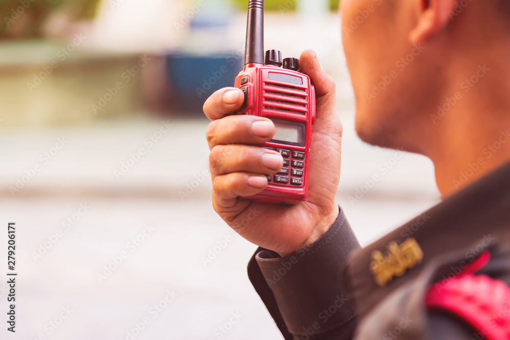 Security guard uses radio communication for facilitate traffic. Traffic ...