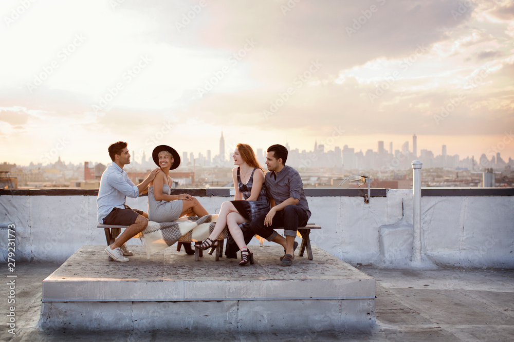 Smiling friends sitting on bench outdoors Stock Photo | Adobe Stock