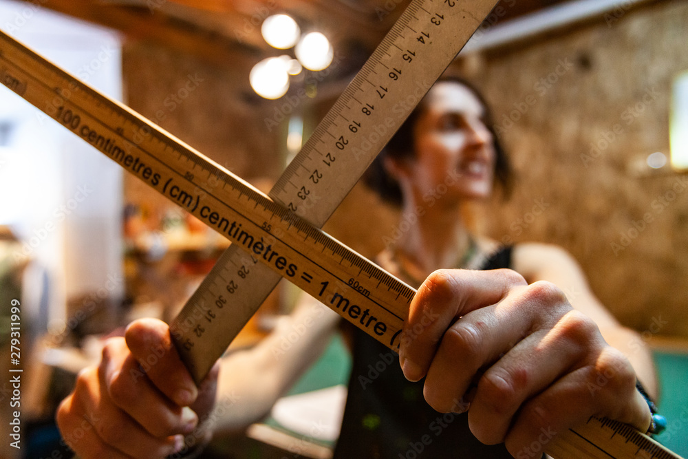 Stockfoto med beskrivningen Fashion designer holding wooden rulers. A ...