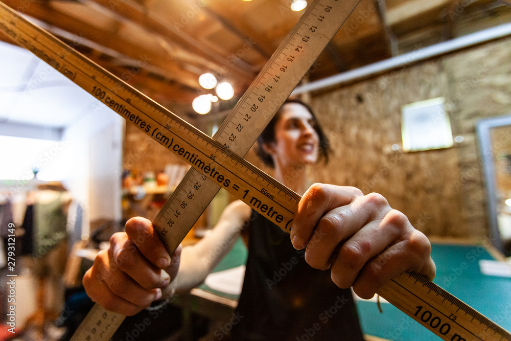 Fashion designer holding wooden rulers. A closeup view of two wood ...