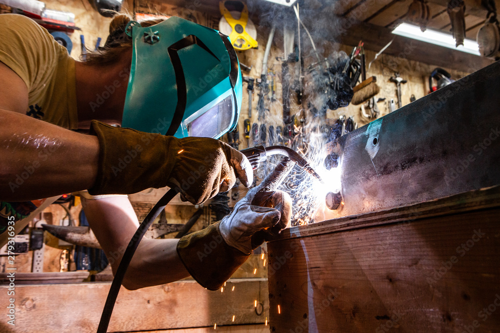 Metalworker operates spot welder indoors. A closeup view of a skilled ...