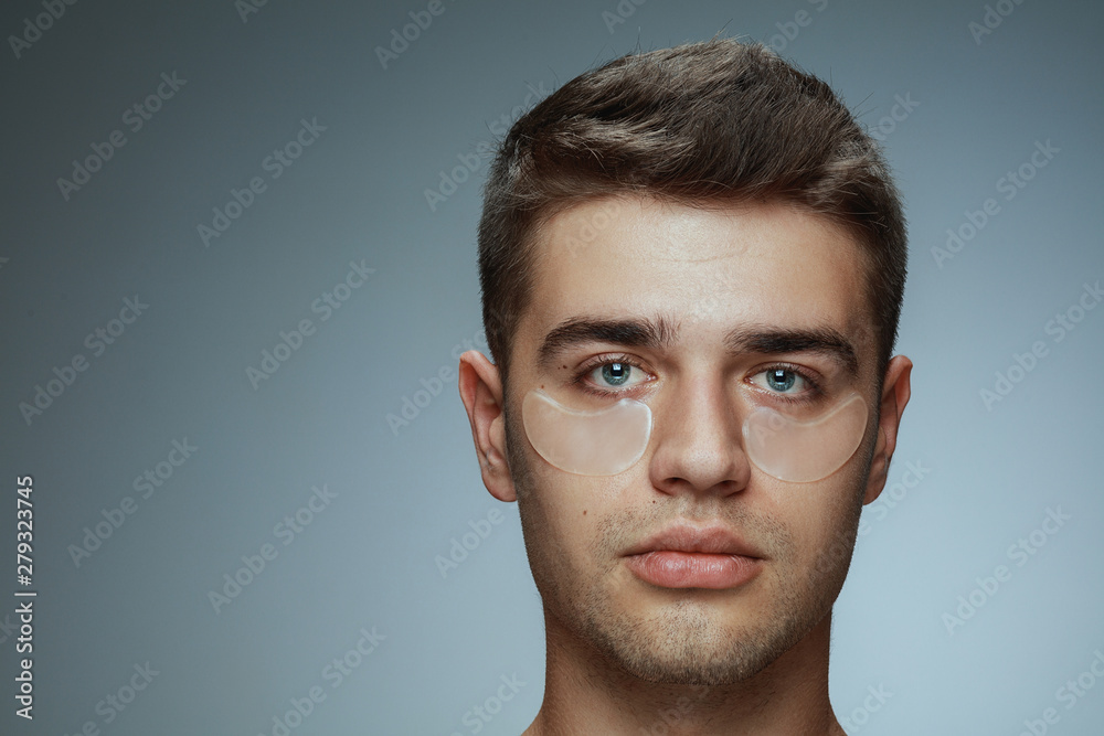 Close-up profile portrait of young man isolated on grey studio ...