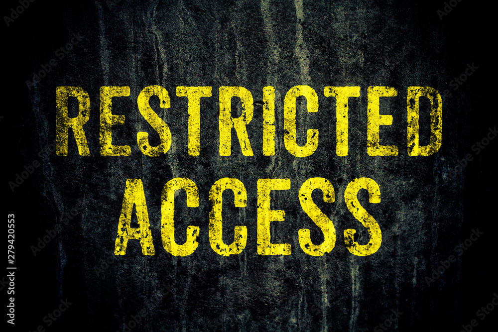 Restricted access warning danger sign in yellow letters painted over ...