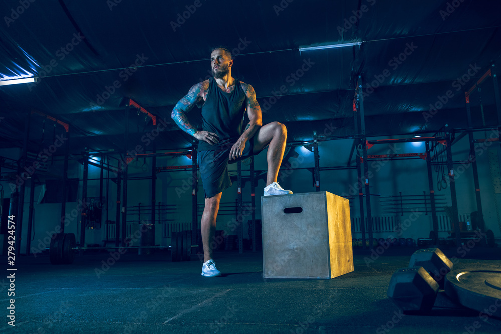 Young healthy man athlete doing exercise with the stand in the gym ...