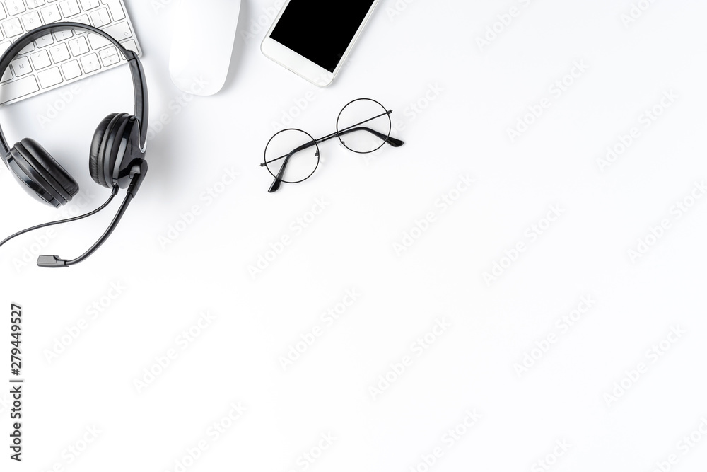 Call center desktop with headset and accessories on white table. Top ...
