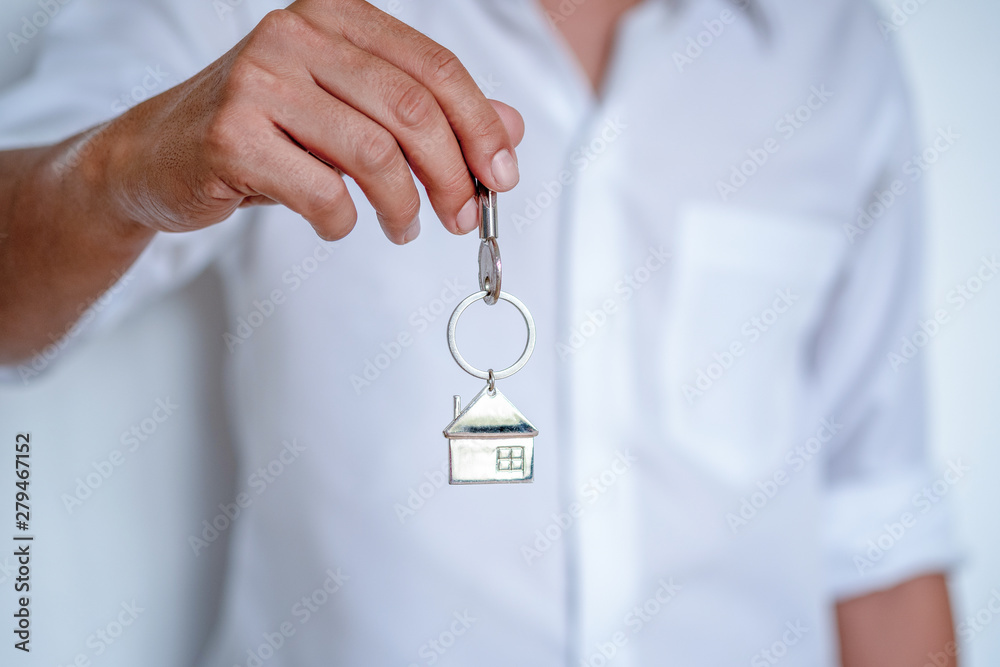Real estate agent handing over house keys, Men hand holding key with ...