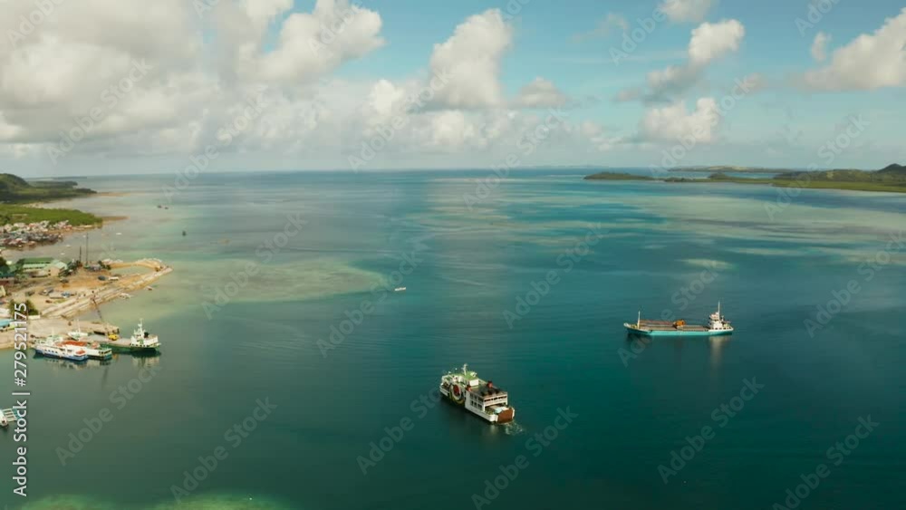 Passenger port with ferries and cargo ships on the island of Siargao ...