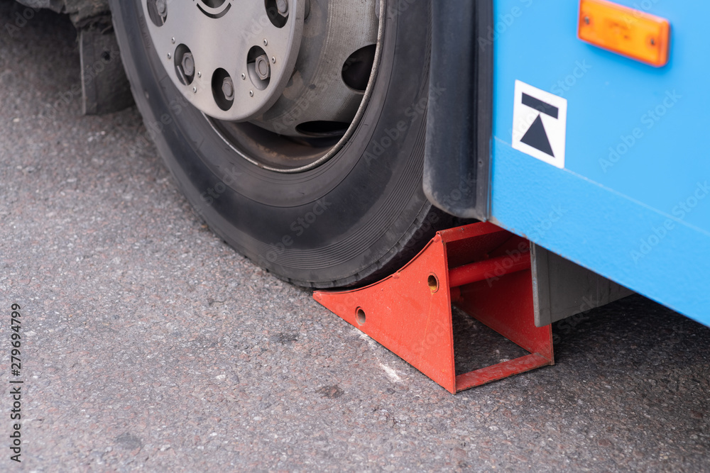 wheel chock under the wheel of the bus. Safety in the operation of ...