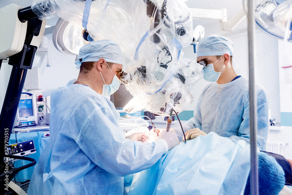 Spinal surgery. Group of surgeons in operating room with surgery ...