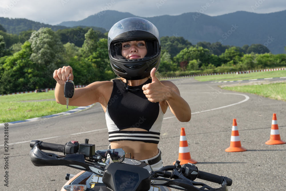 Beginning driver on the moto track shows the keys to the motorbike ...