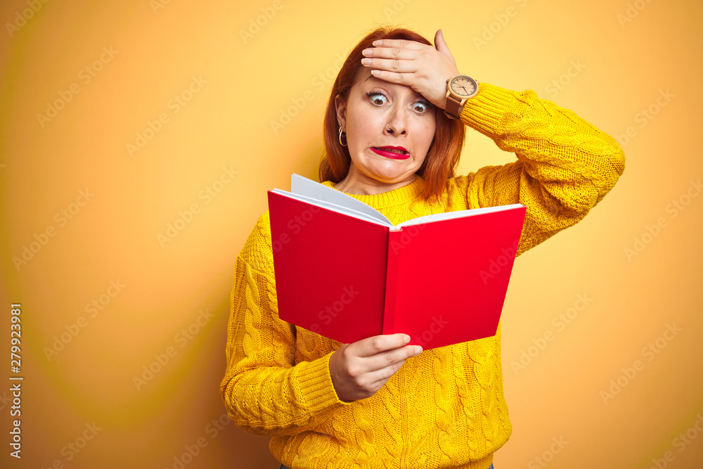 Young redhead teacher woman reading red book over yellow isolated ...
