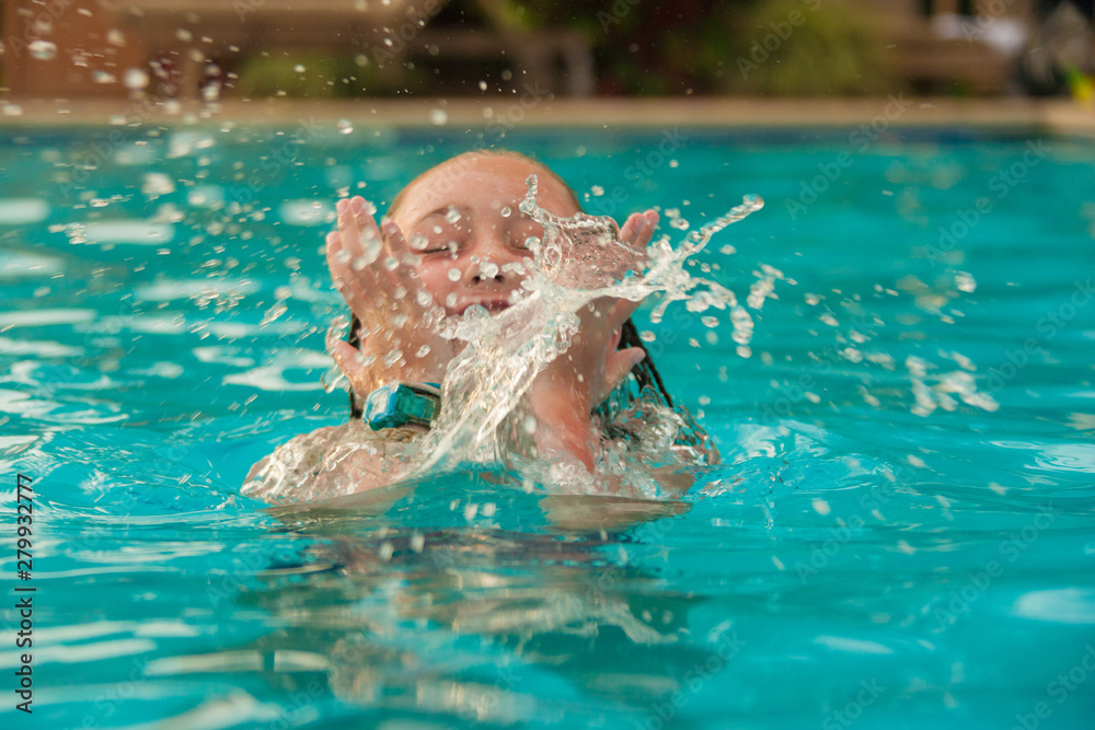 Young girl splashing water in a pool at a resort in Cruz Bay, St. John ...