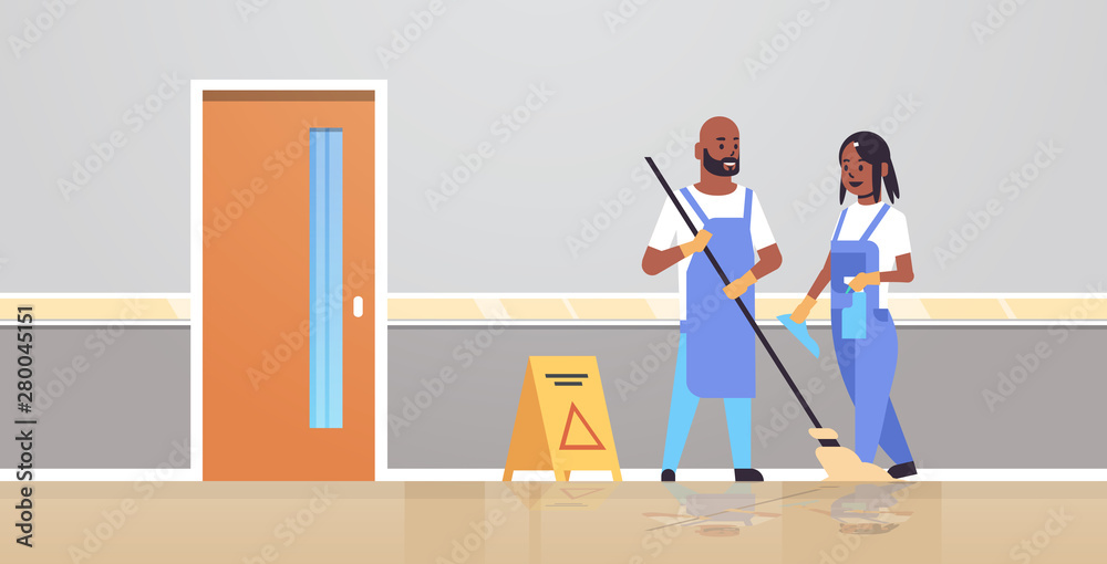 couple cleaners in uniform working together cleaning service concept ...