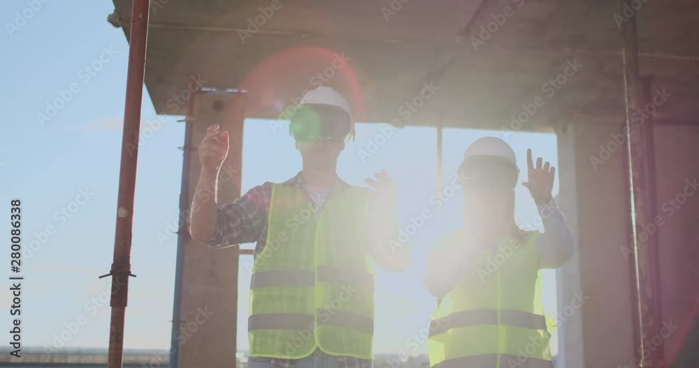 Two contemporary crew workers using VR to visualize projects standing ...