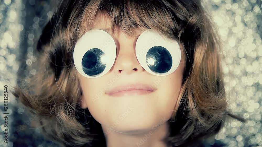 A little girl with funny big googly eyes. Close-up shot of the face ...