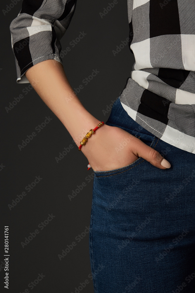 Cropped shot of a woman with a bracelet on her wrist. The red bracelet ...