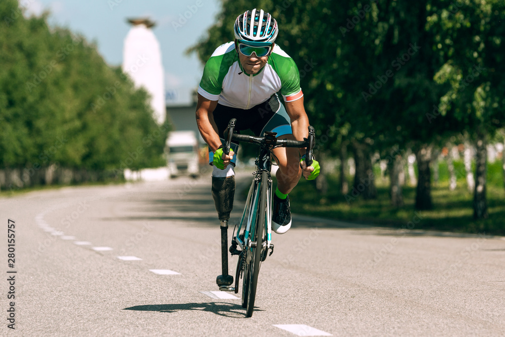 Athlete with disabilities or amputee training in cycling in sunny ...