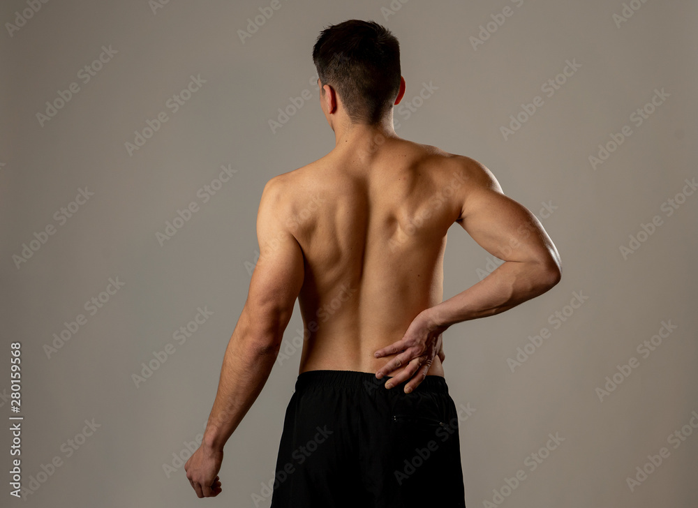 Strong young man suffering lower back pain in stress and bad posture ...