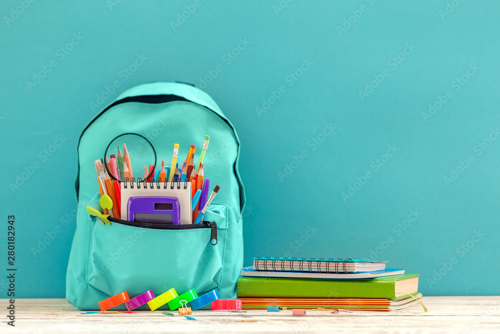 Full blue School Backpack with different supplies on blue background ...