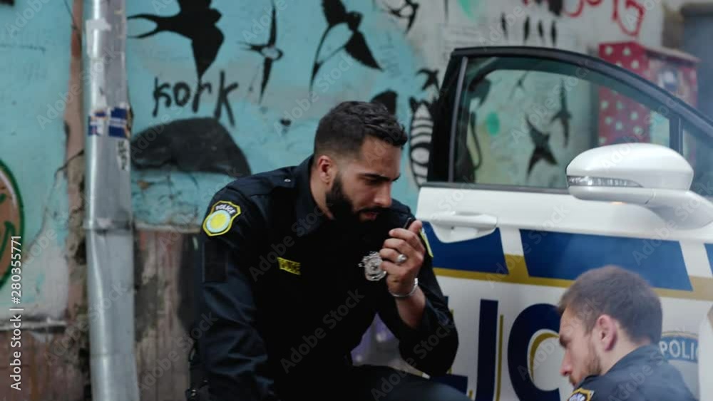 Dangerous city. View of policeman injured in shootout leaning on the ...
