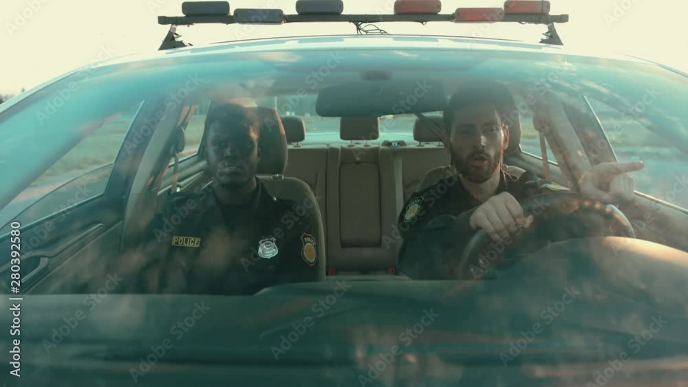 Curious policeman driving patrol car with his colleague to the ...