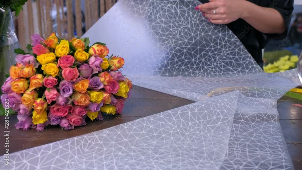 Floral business concept. Woman florist is packaging bouquet of small ...
